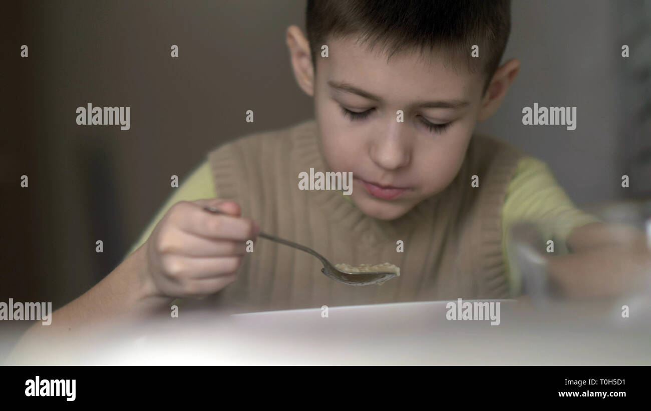 Boy eating with soup spoon hi-res stock photography and images - Alamy