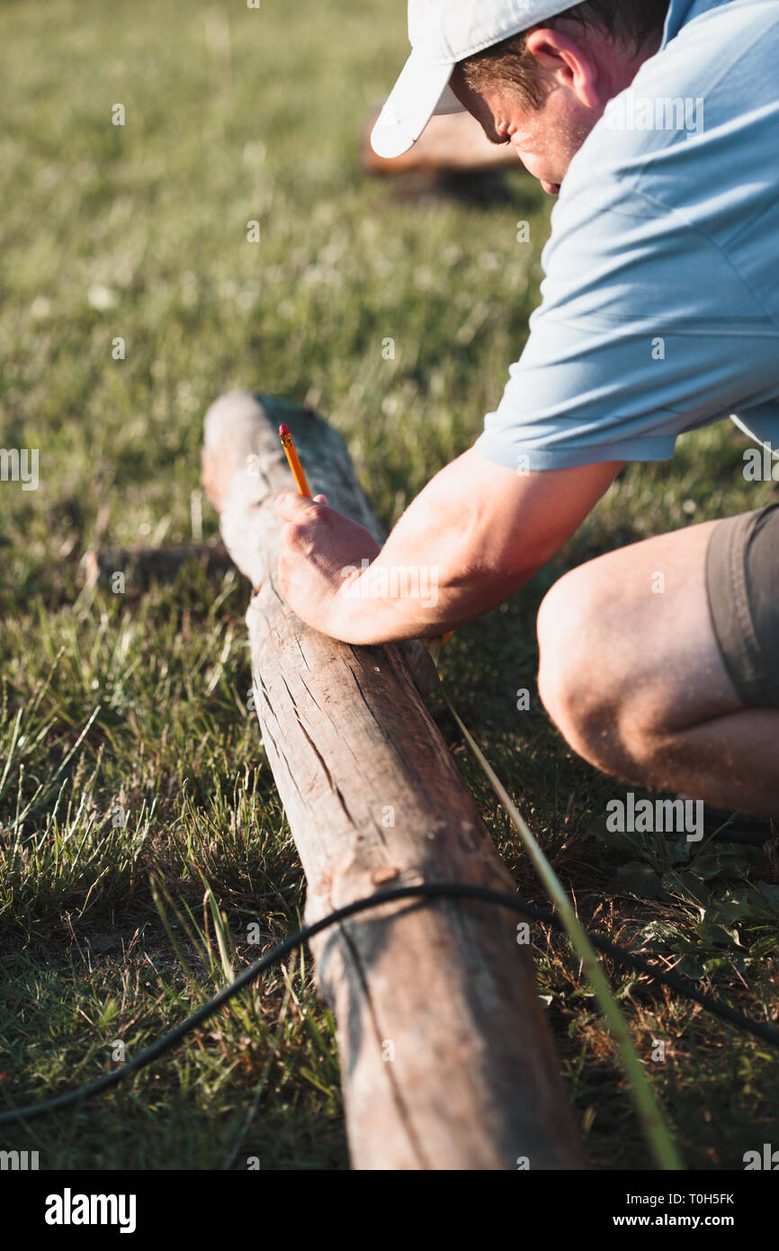 Man making mark by using pencil after measuring of timber while working ...