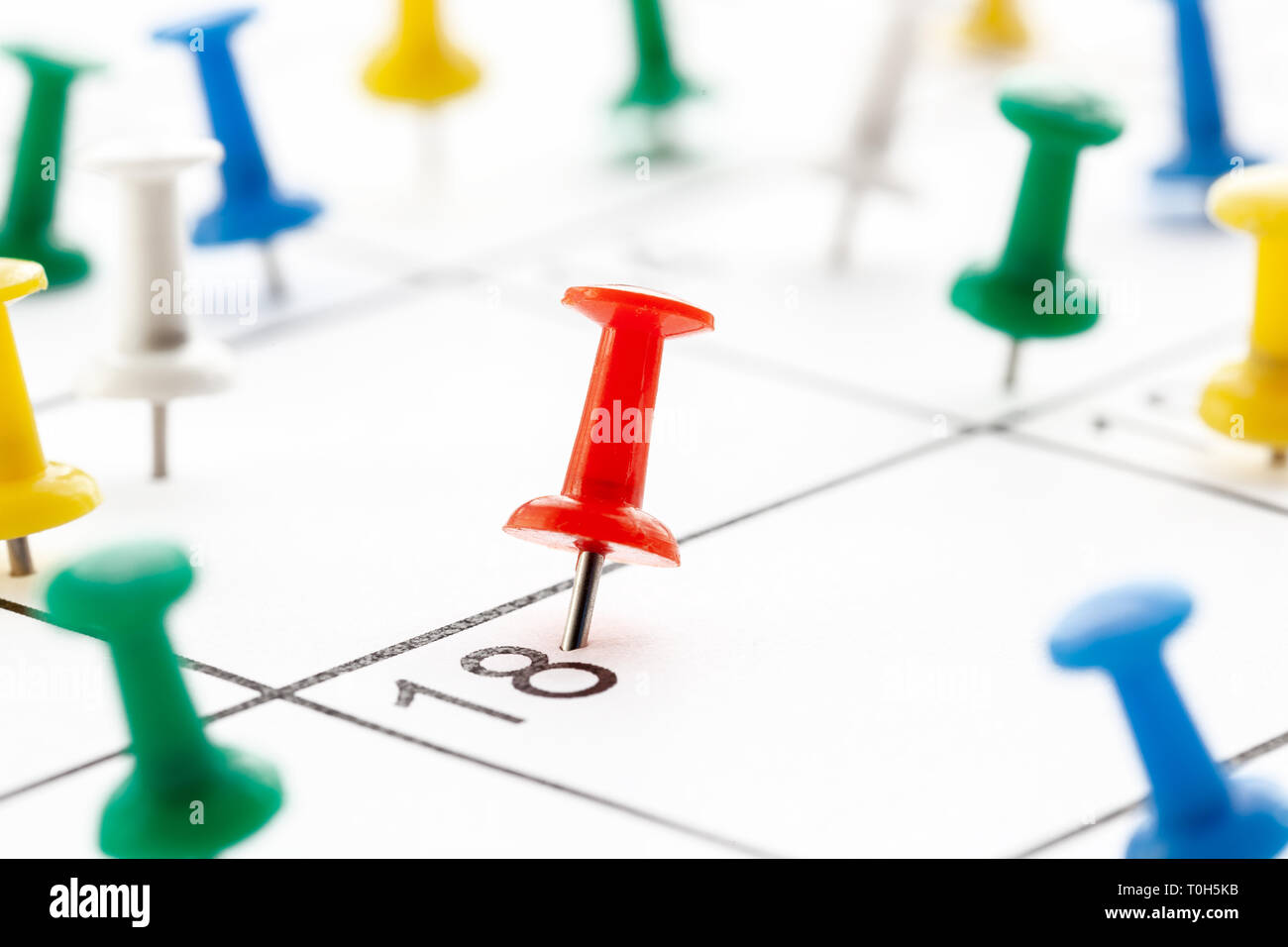 Colored push pin on white calendar background Stock Photo - Alamy