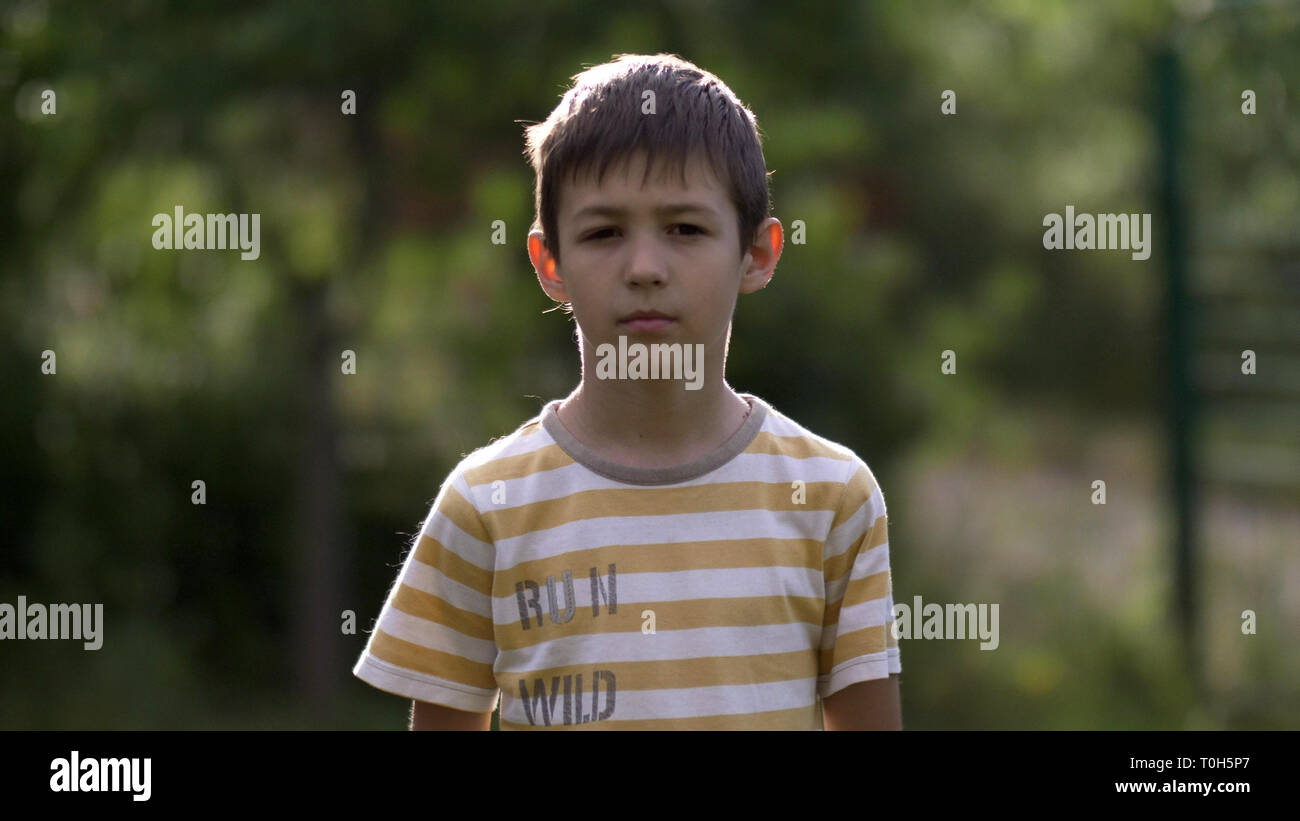 portrait of a serious boy looking at the camera on nature Stock Photo ...
