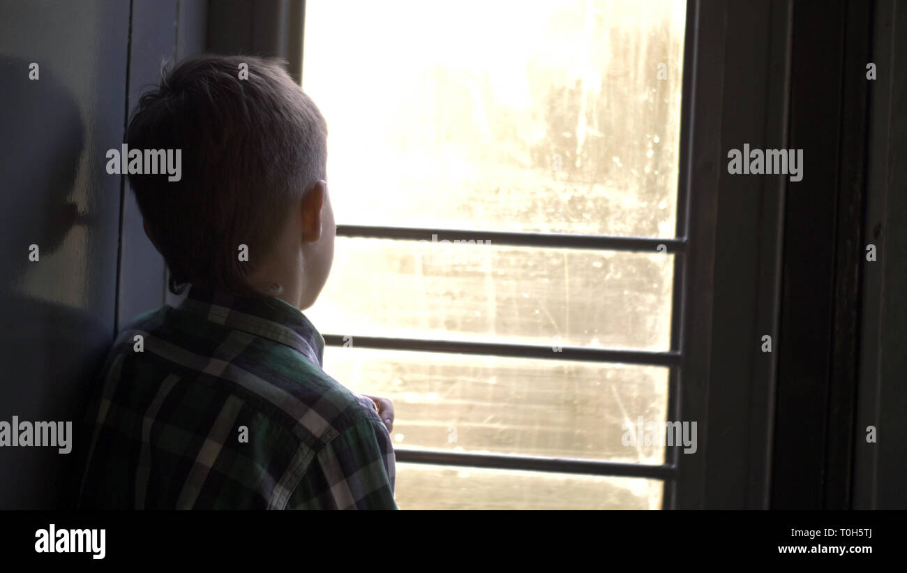 Boy looking out window sad hi-res stock photography and images - Alamy