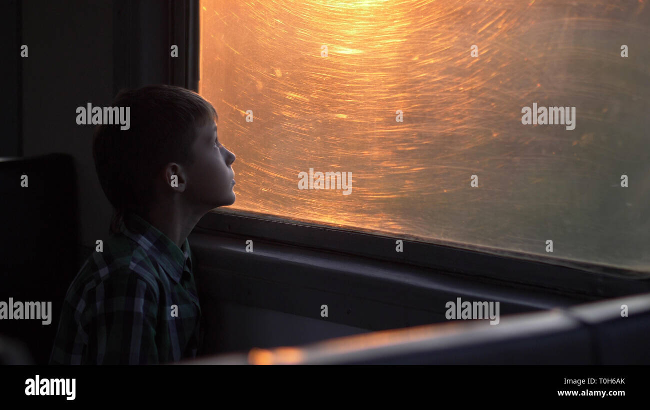 Boy Rides On A Train In The Evening Looks Out The Window Stock Photo ...