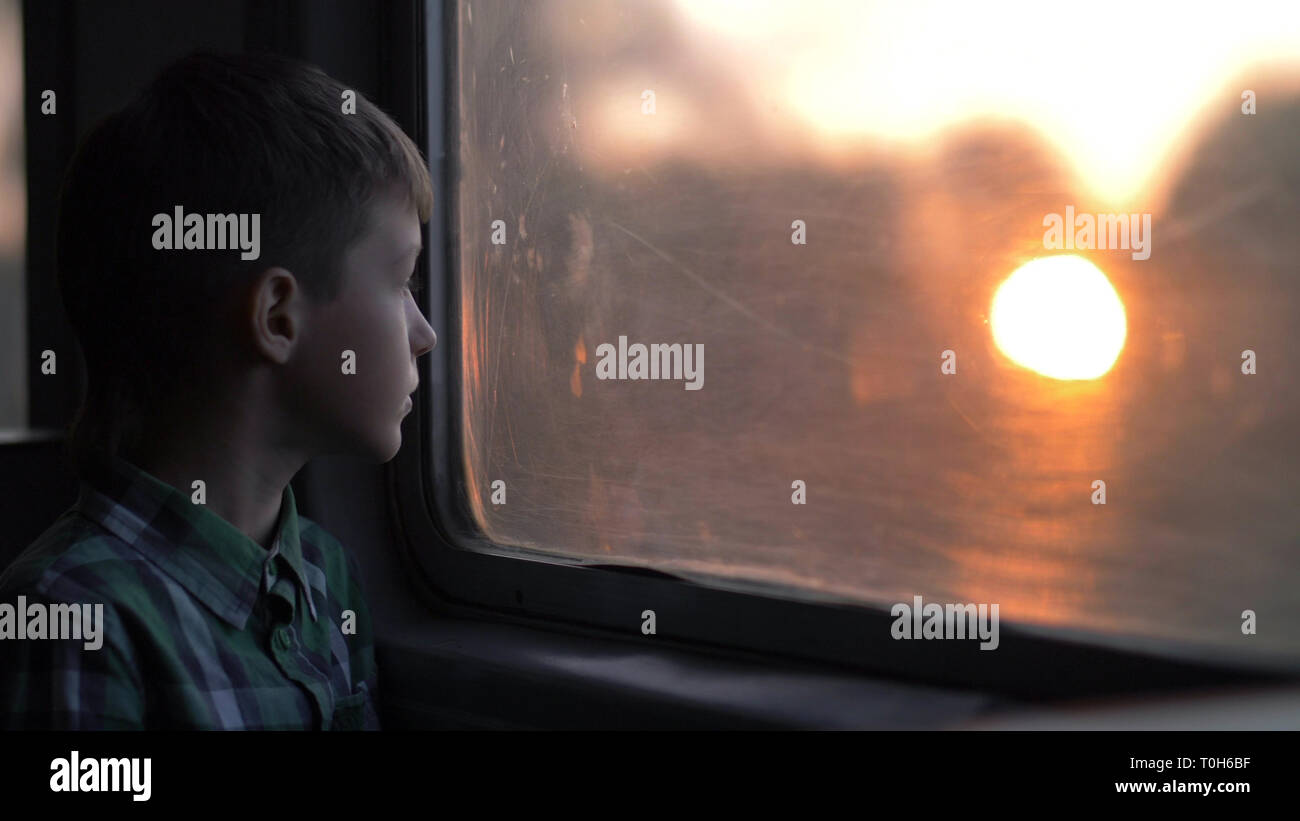Boy Rides On A Train In The Evening Looks Out The Window Stock Photo ...