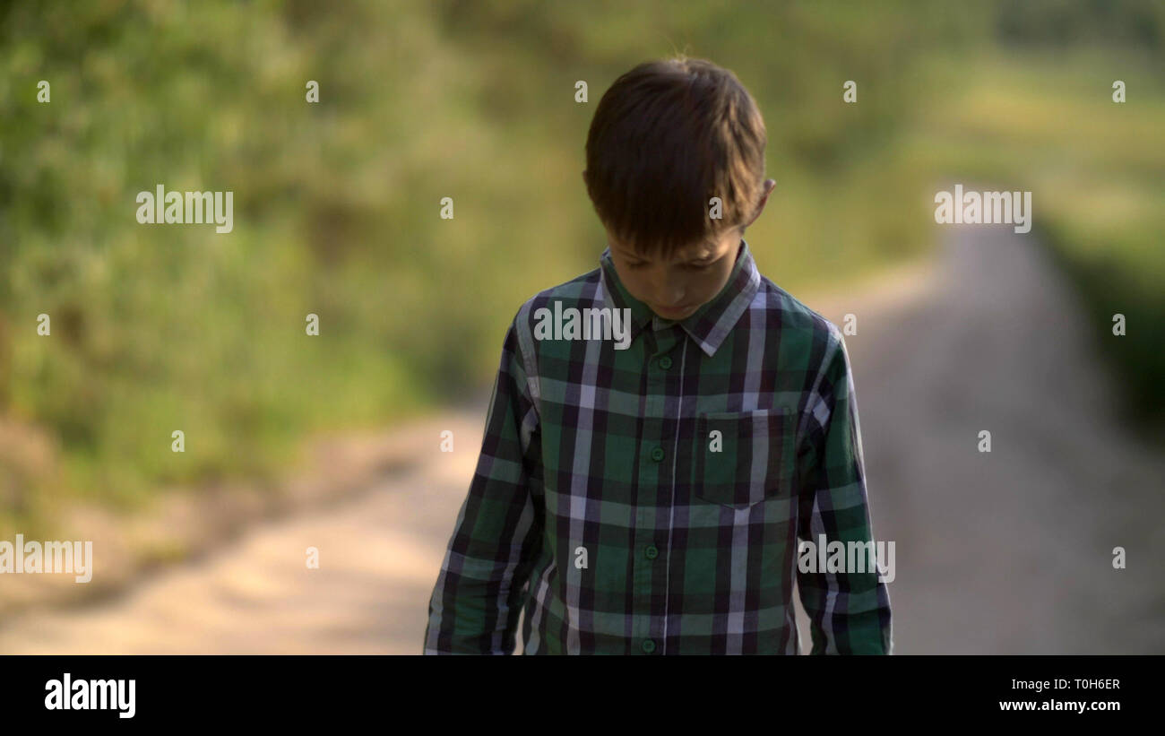 lonely boy lowers head, regret for action, pain on face Stock Photo - Alamy