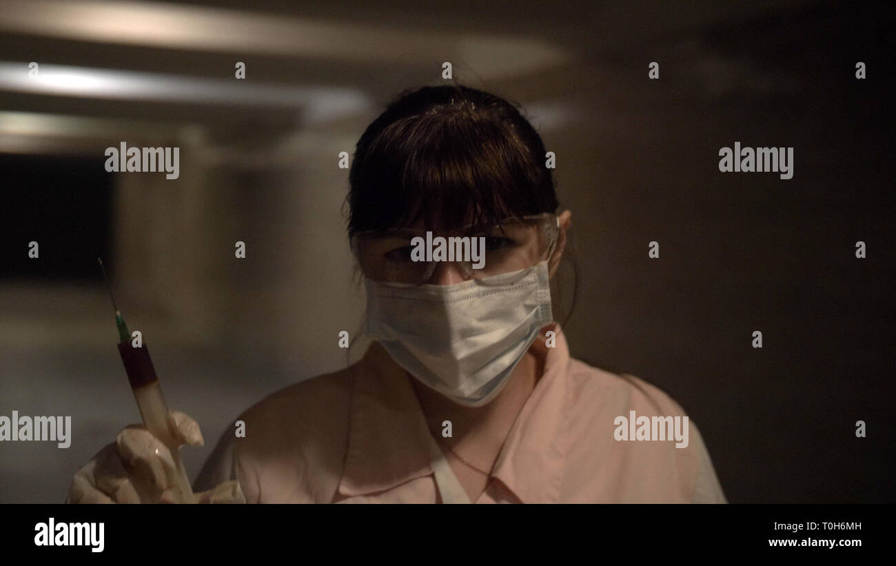 nurse goes to make an injection looks at the camera horror fear of ...