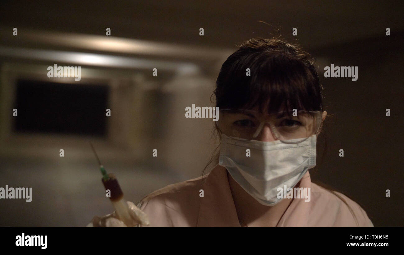 nurse goes to make an injection looks at the camera horror fear of ...