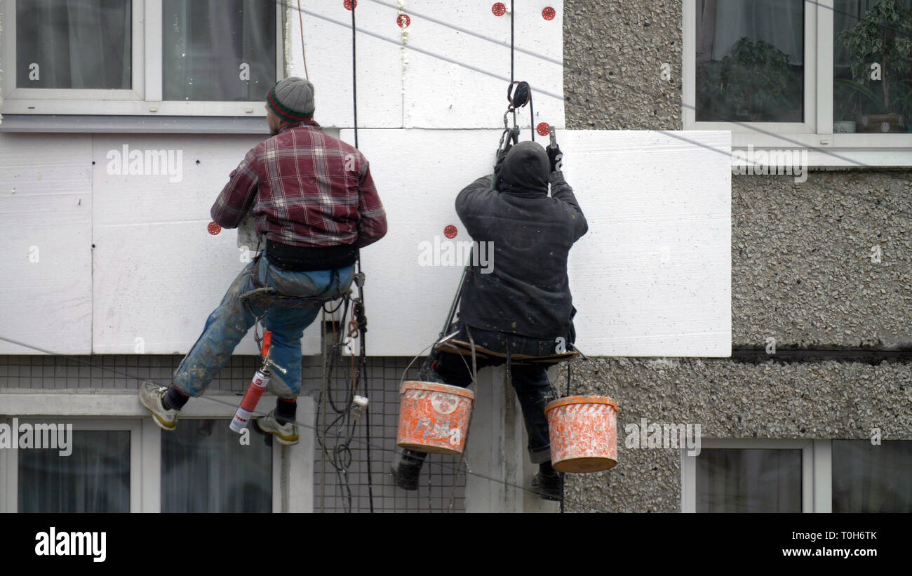climbers work on the building, climbers are working on the insulation ...