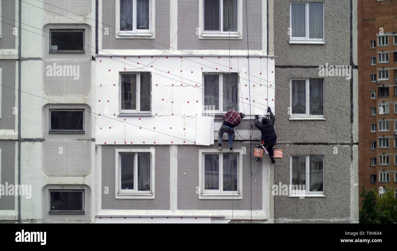 climbers work on the building, climbers are working on the insulation ...