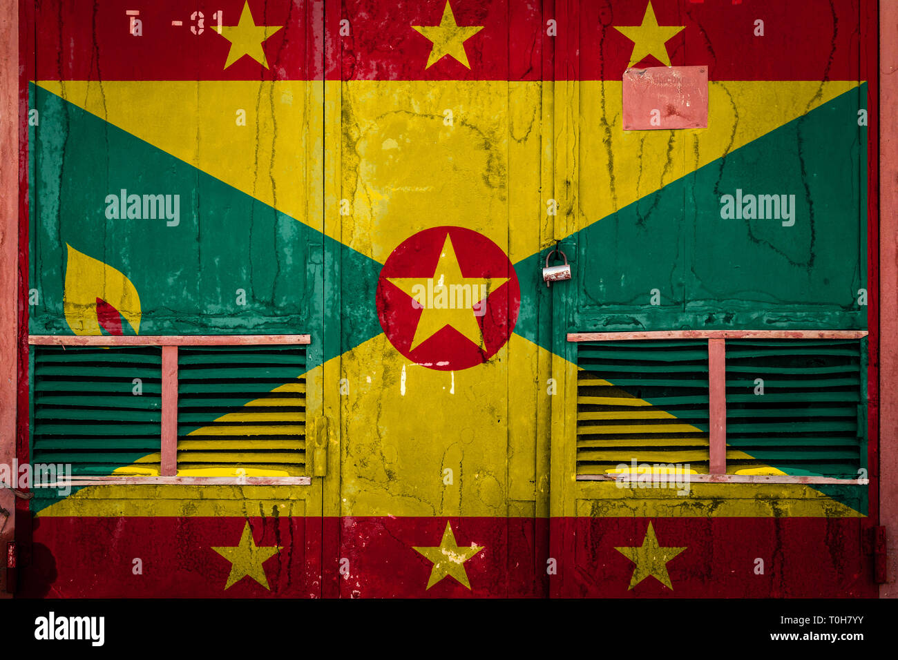 Close-up of old warehouse gate with national flag of Grenada. Concept ...