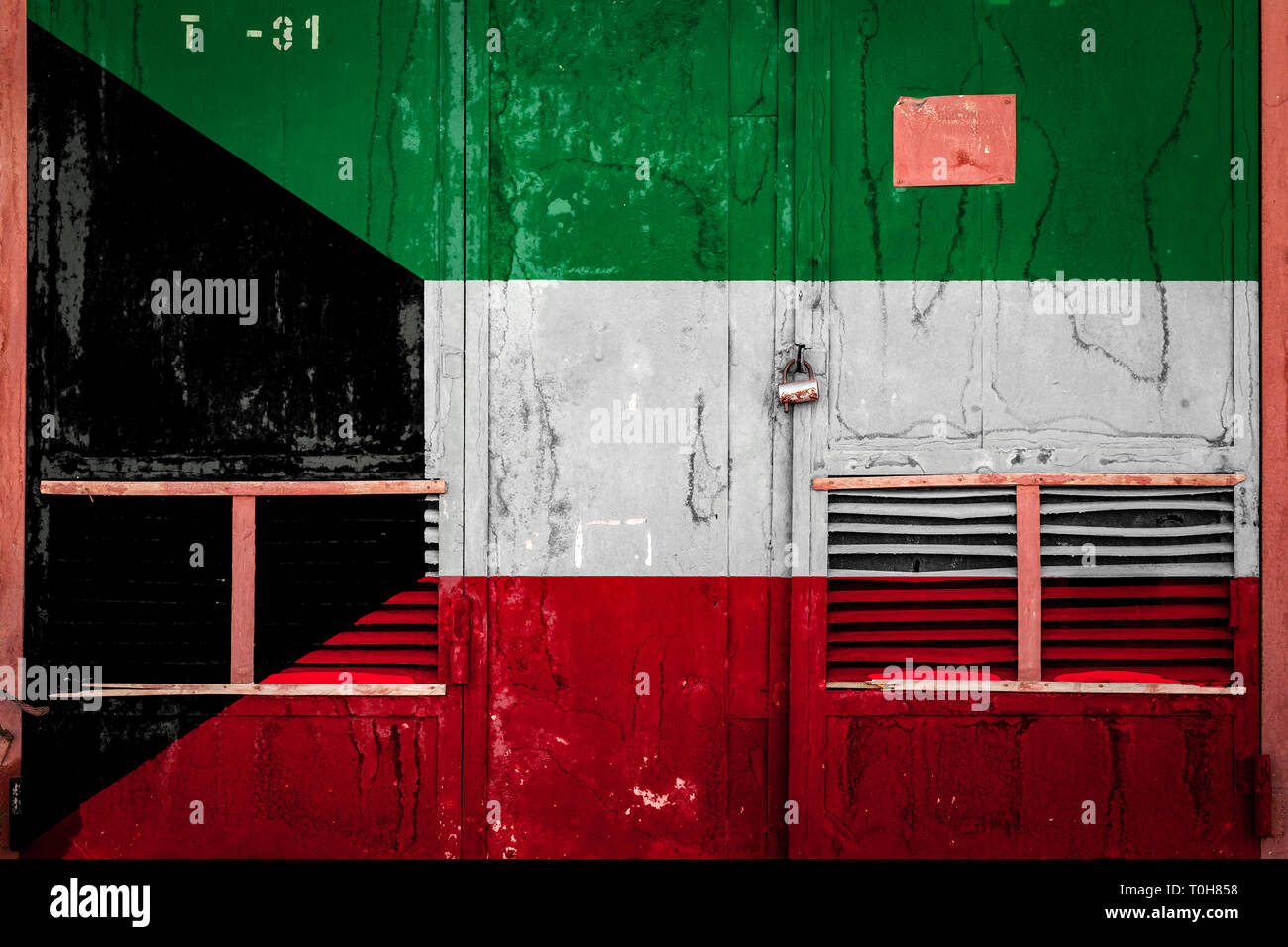 Close-up of old warehouse gate with national flag of Kuwait. Concept of ...