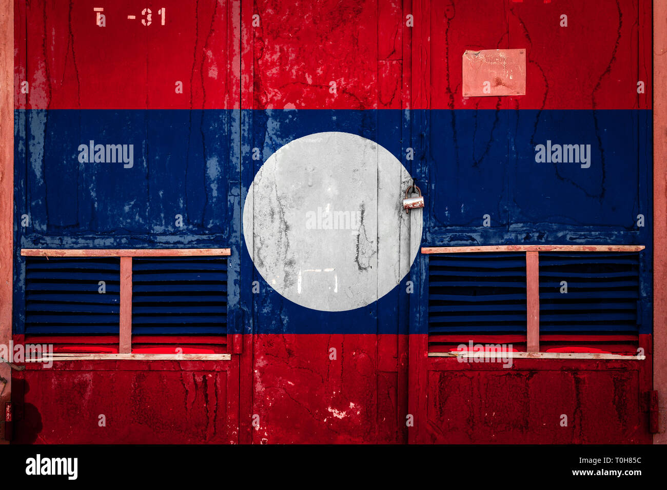 Close-up of old warehouse gate with national flag of Laos. Concept of ...