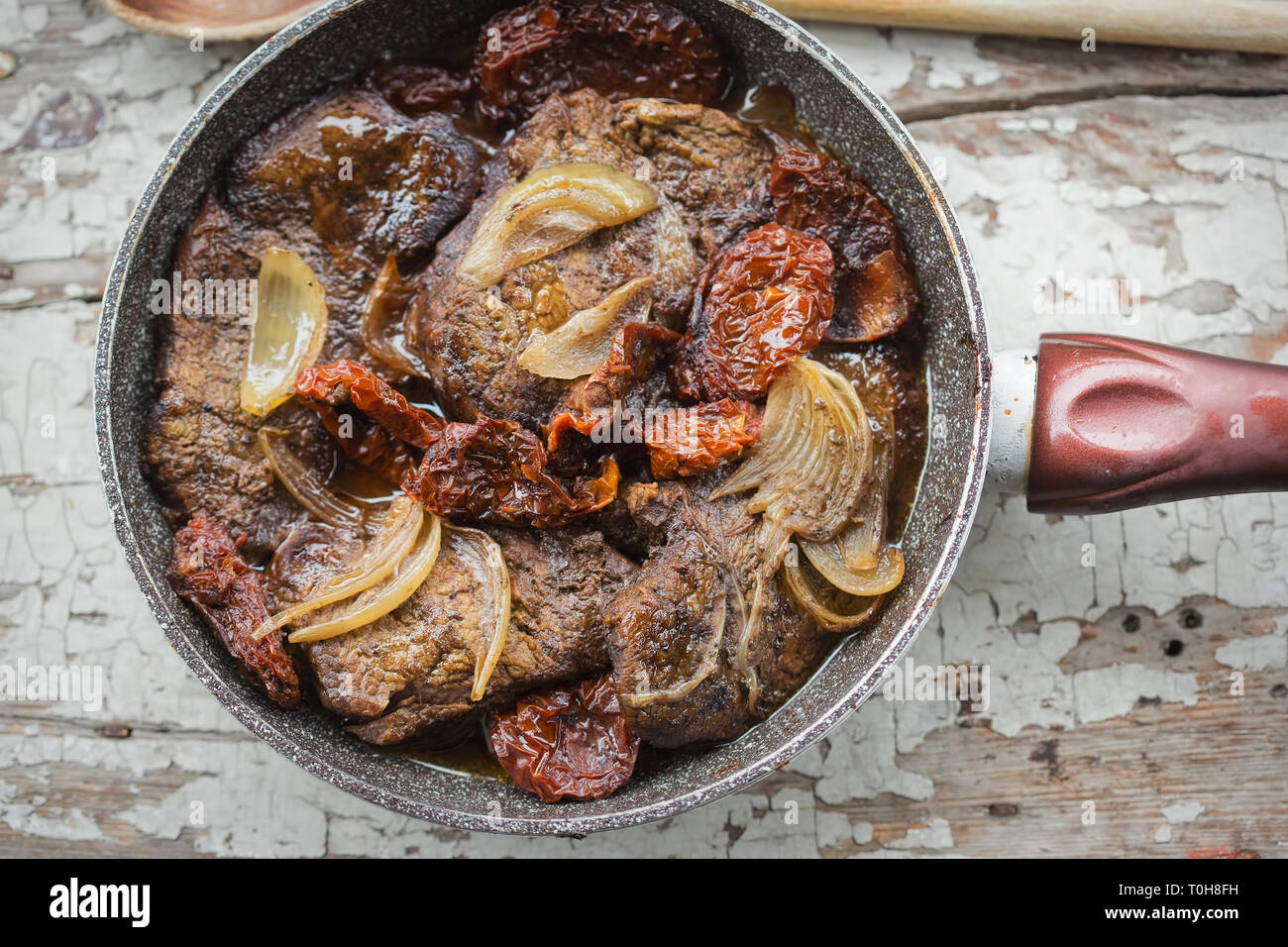 Braised beef steak in red wine with sun dried tomatoes Stock Photo - Alamy