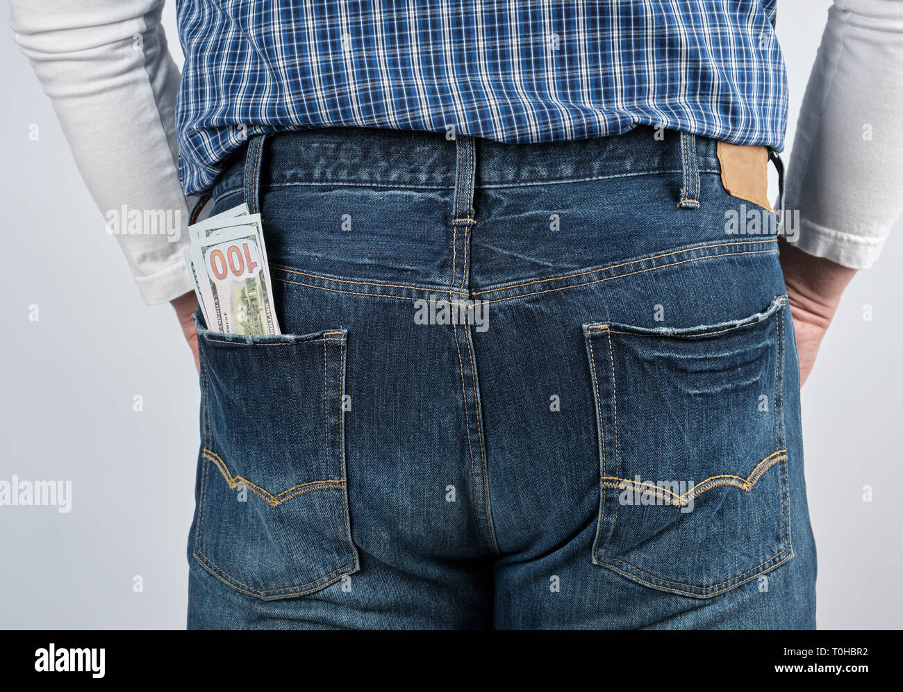 bundle of paper money in the back pocket of blue jeans, white ...
