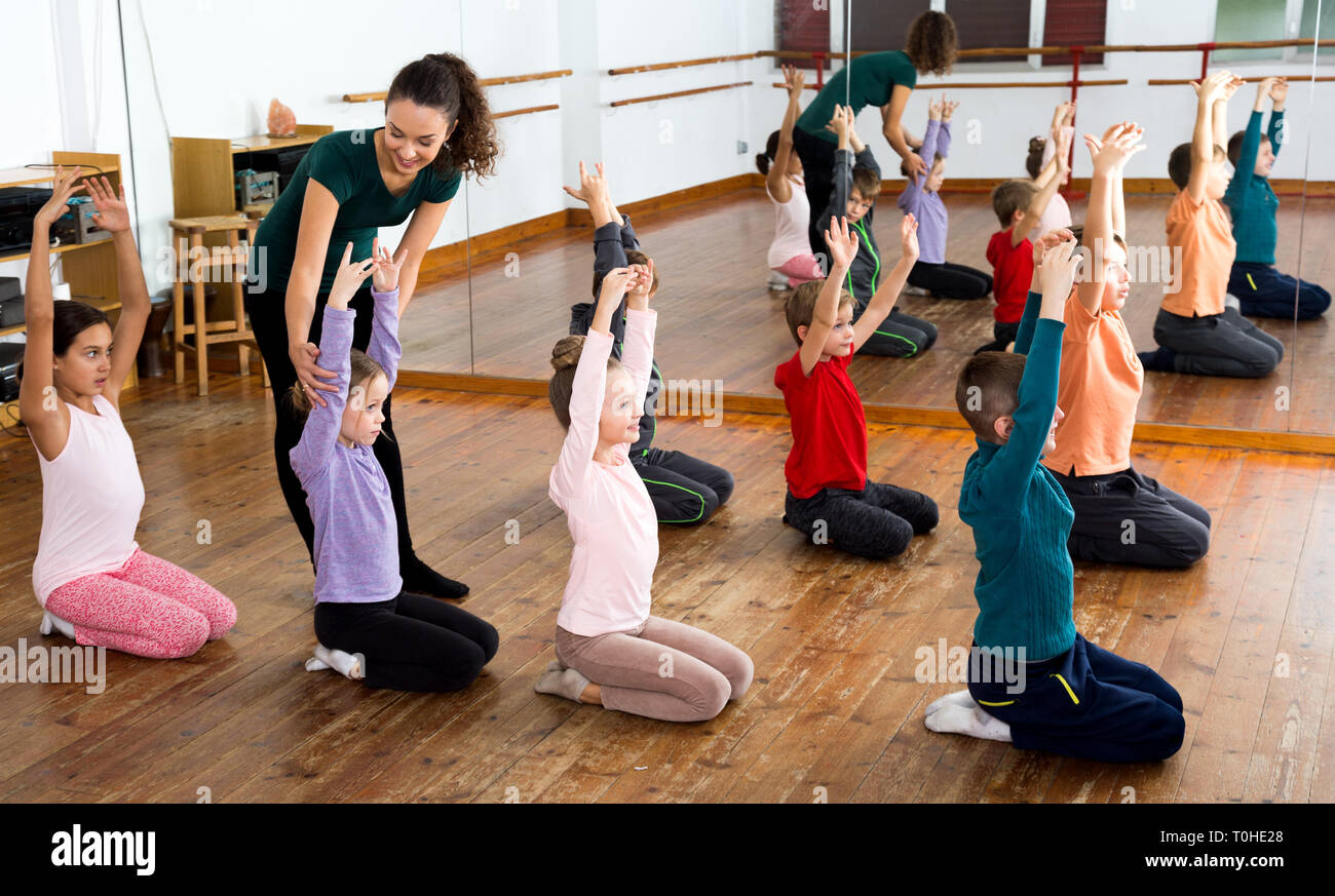 Happy children studying modern style dance in class and their teacher ...