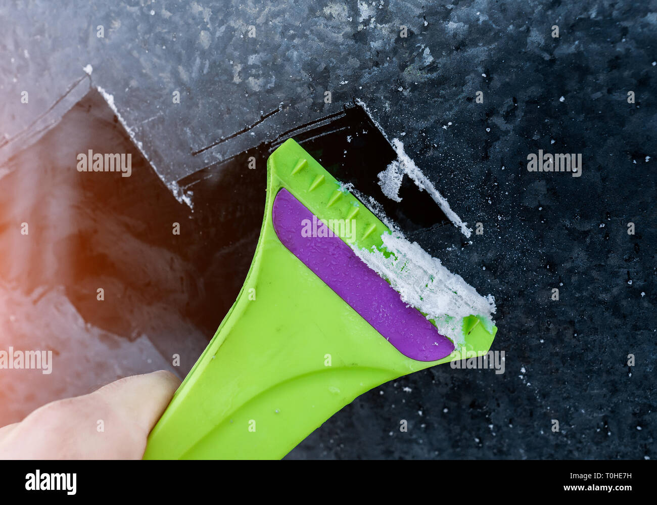 Cleaning frozen car window from the ice Stock Photo - Alamy