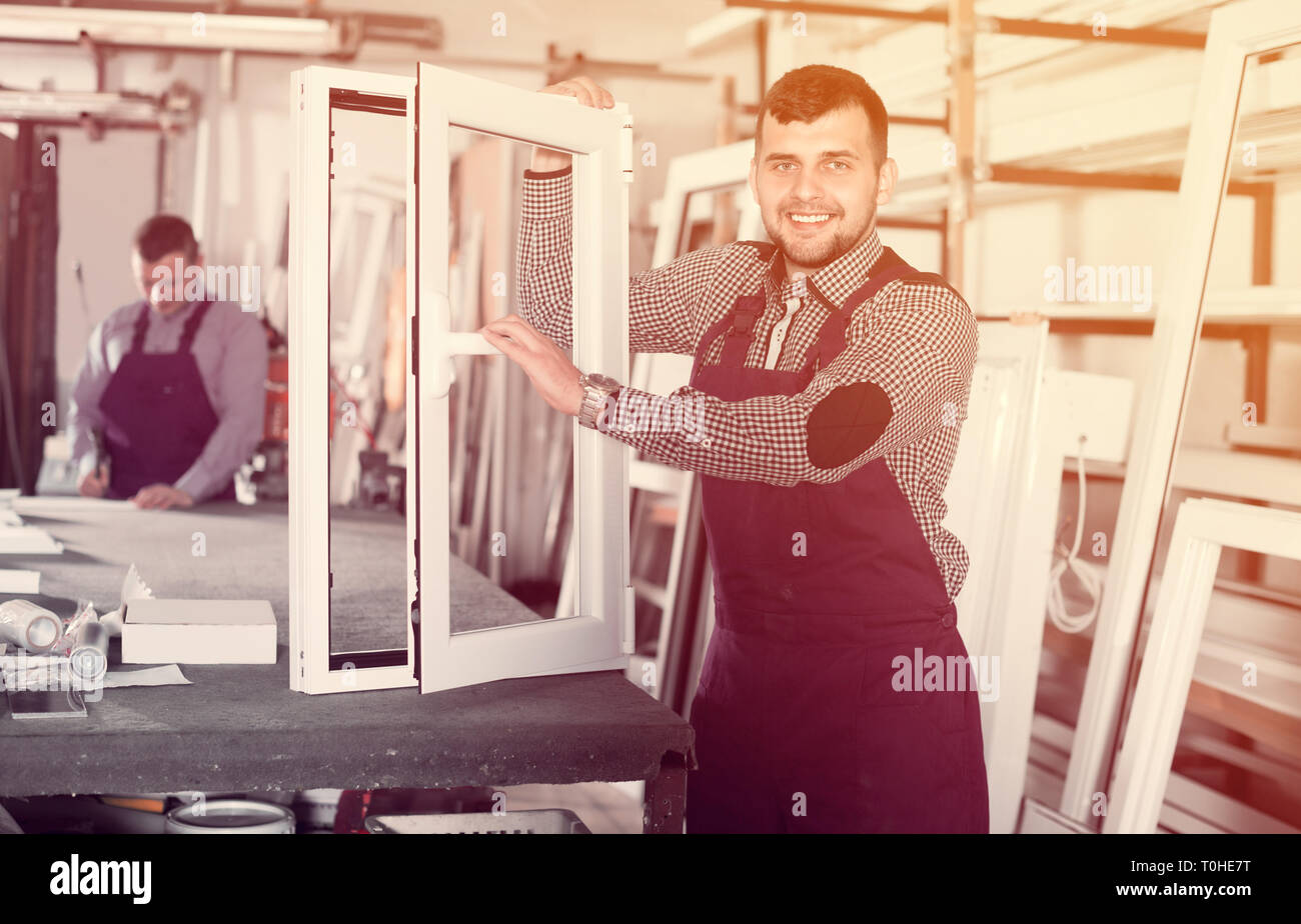 Workman is demonstrating the window frame in workshop Stock Photo - Alamy