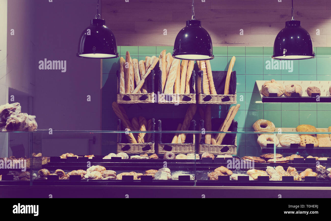 Modern design of bakery counter with bright lamps and glass showcase ...