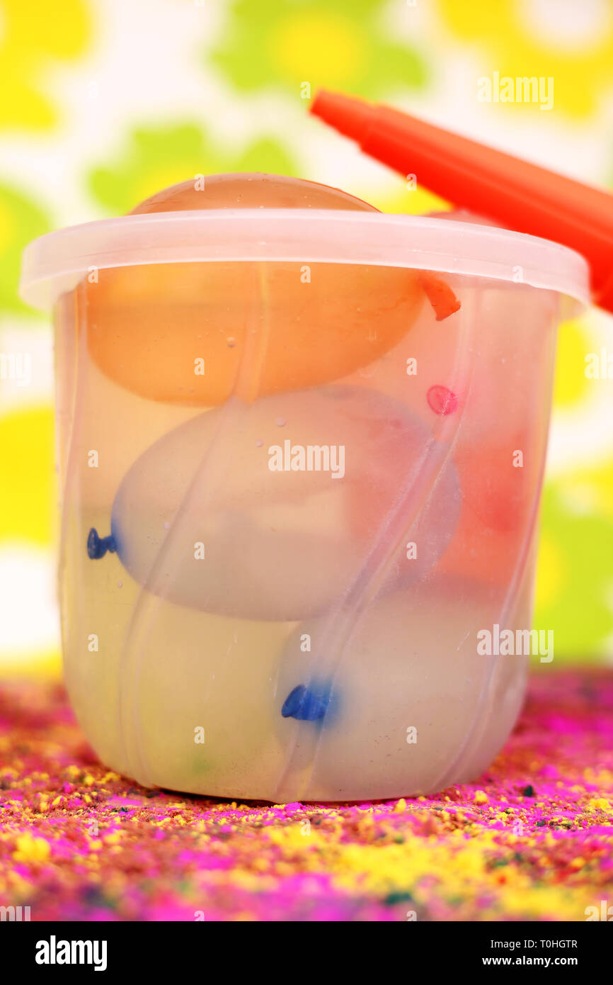 Picture of colorful water balloons in bucket with pichkari for holi fun ...