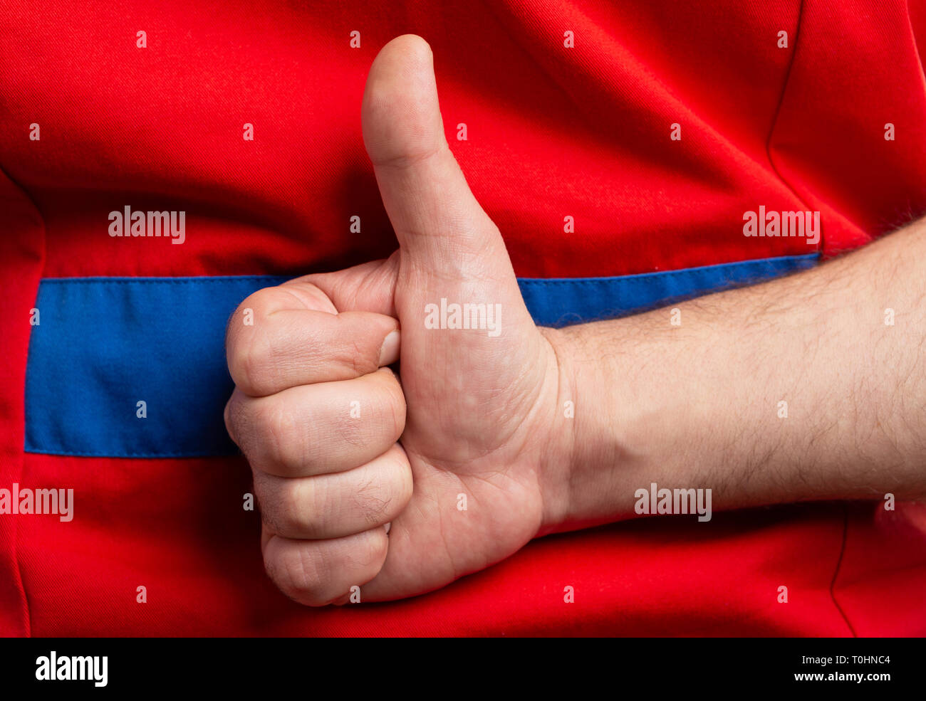 Closeup of man working at hypermarket or supermarket showing thumb up ...