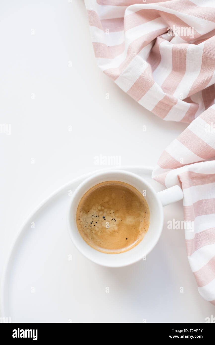 Fresh coffee and cloth with beige stripes on white background ...
