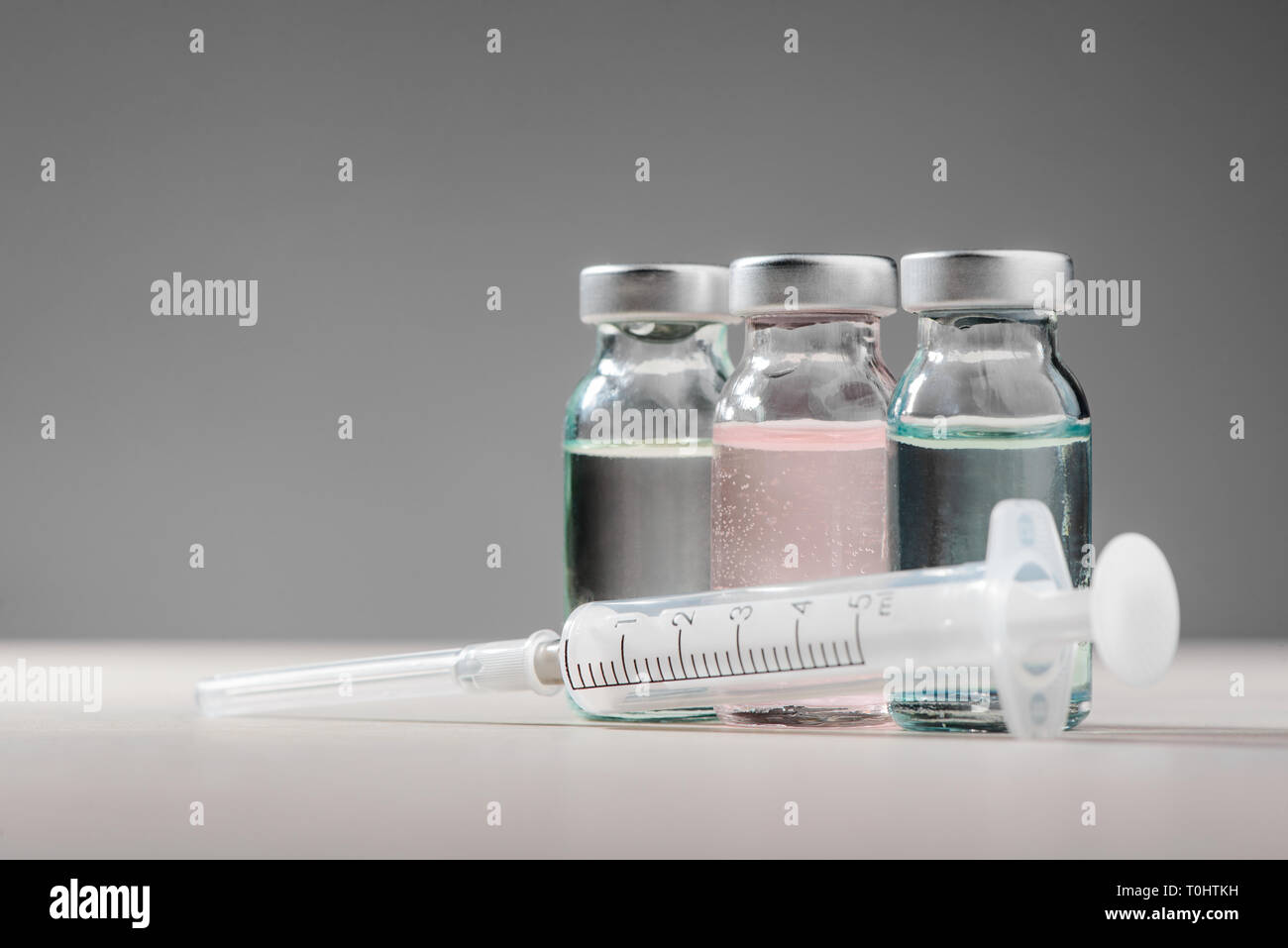 Three vials and syringe Stock Photo - Alamy