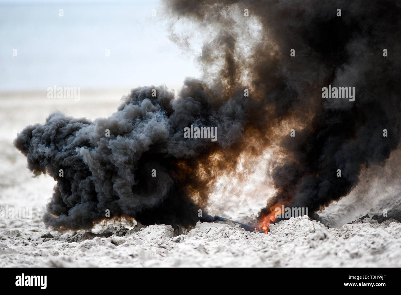 Explosion on the beach, billowing black smoke Stock Photo - Alamy