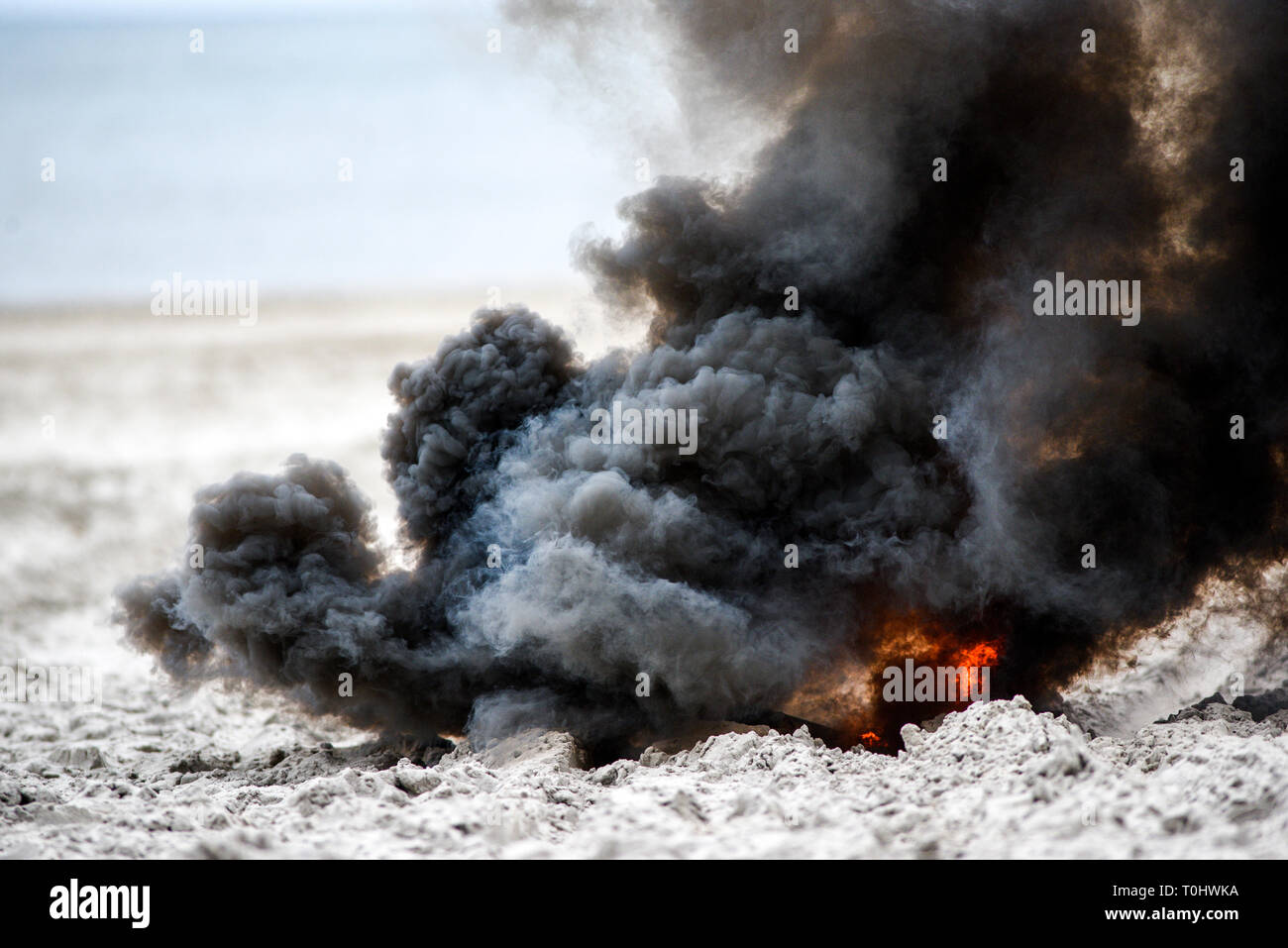 Explosion on the beach, billowing black smoke Stock Photo - Alamy