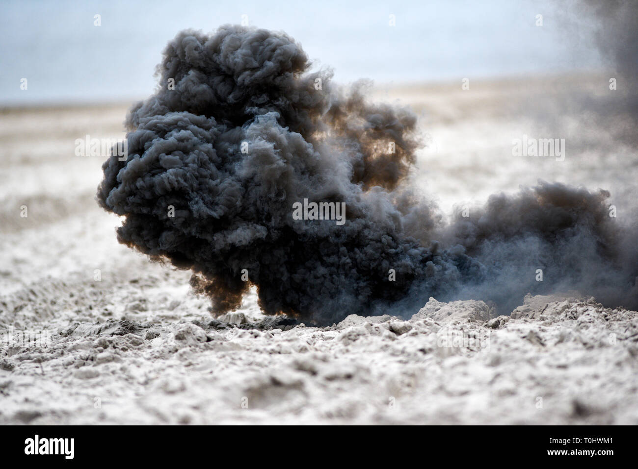 Explosion on the beach, billowing black smoke Stock Photo - Alamy
