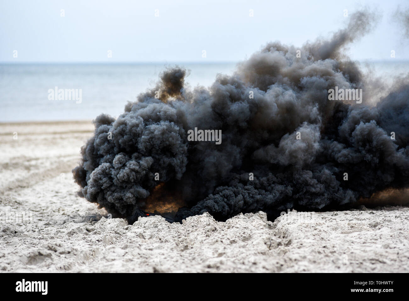 Explosion on the beach, billowing black smoke Stock Photo - Alamy