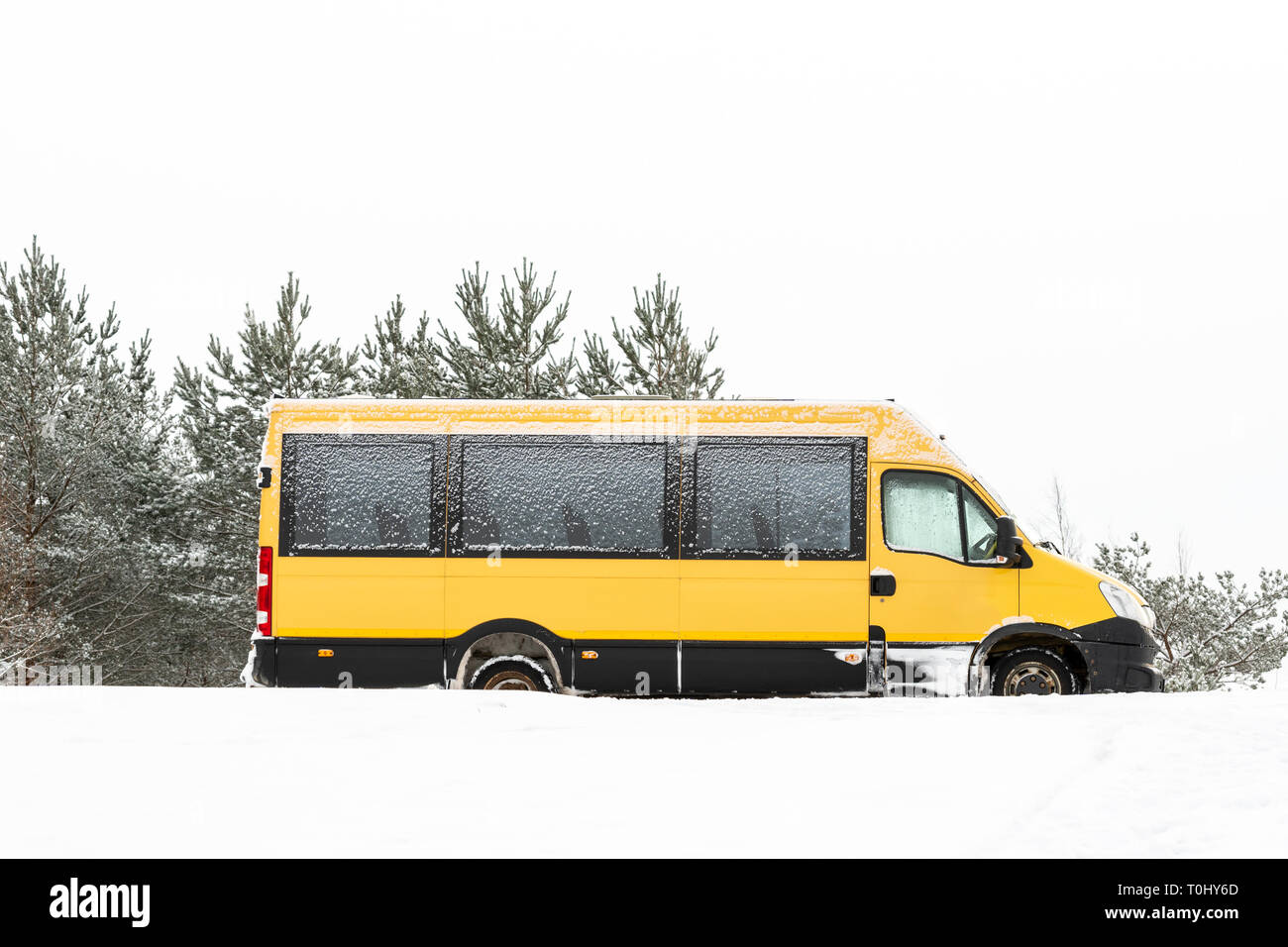 School bus covered with fresh snow. Minibus under the snow. Sleet slush ...