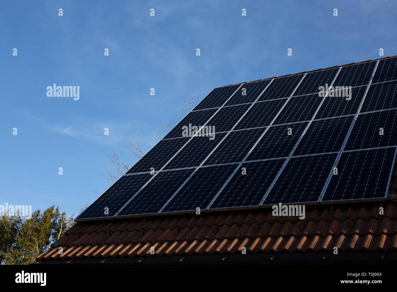 Solar panels on a rooftop against blue sky Stock Photo - Alamy