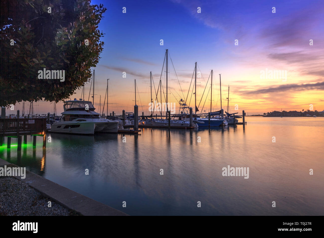 Break of dawn sunrise over boats and sailboats at Factory Bay marina in ...
