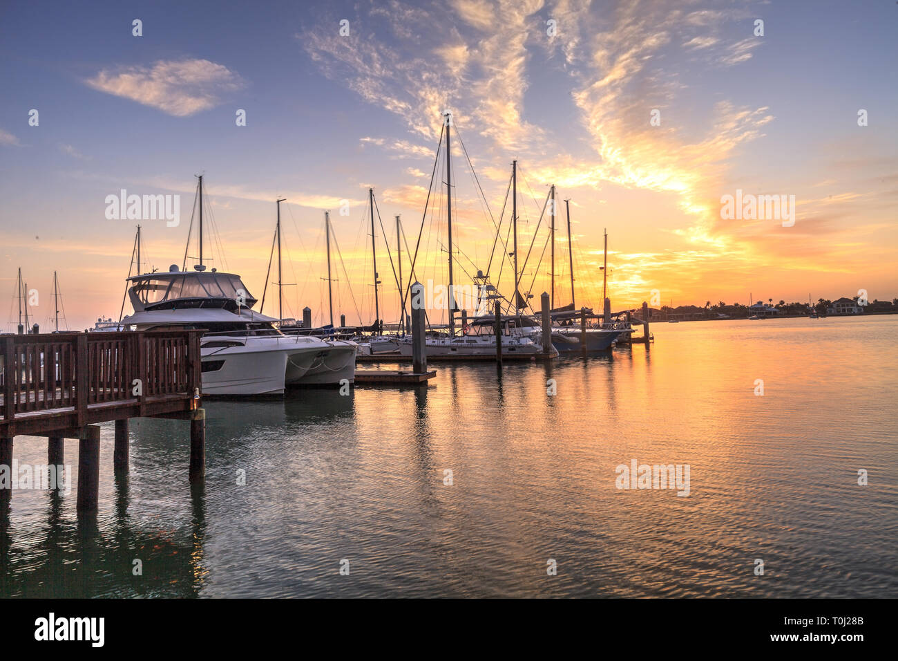 Break of dawn sunrise over boats and sailboats at Factory Bay marina in ...