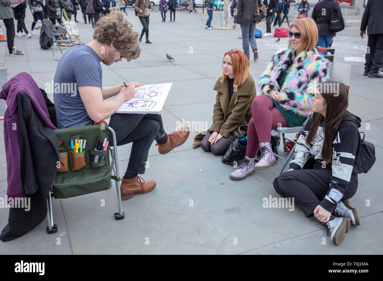 Street artist makes a drawing of three women tourists on Trafalgar ...