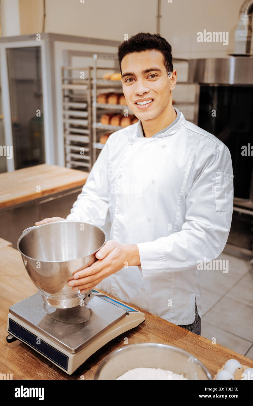 Dark-eyed baker using kitchen scale while cooking bread Stock Photo - Alamy