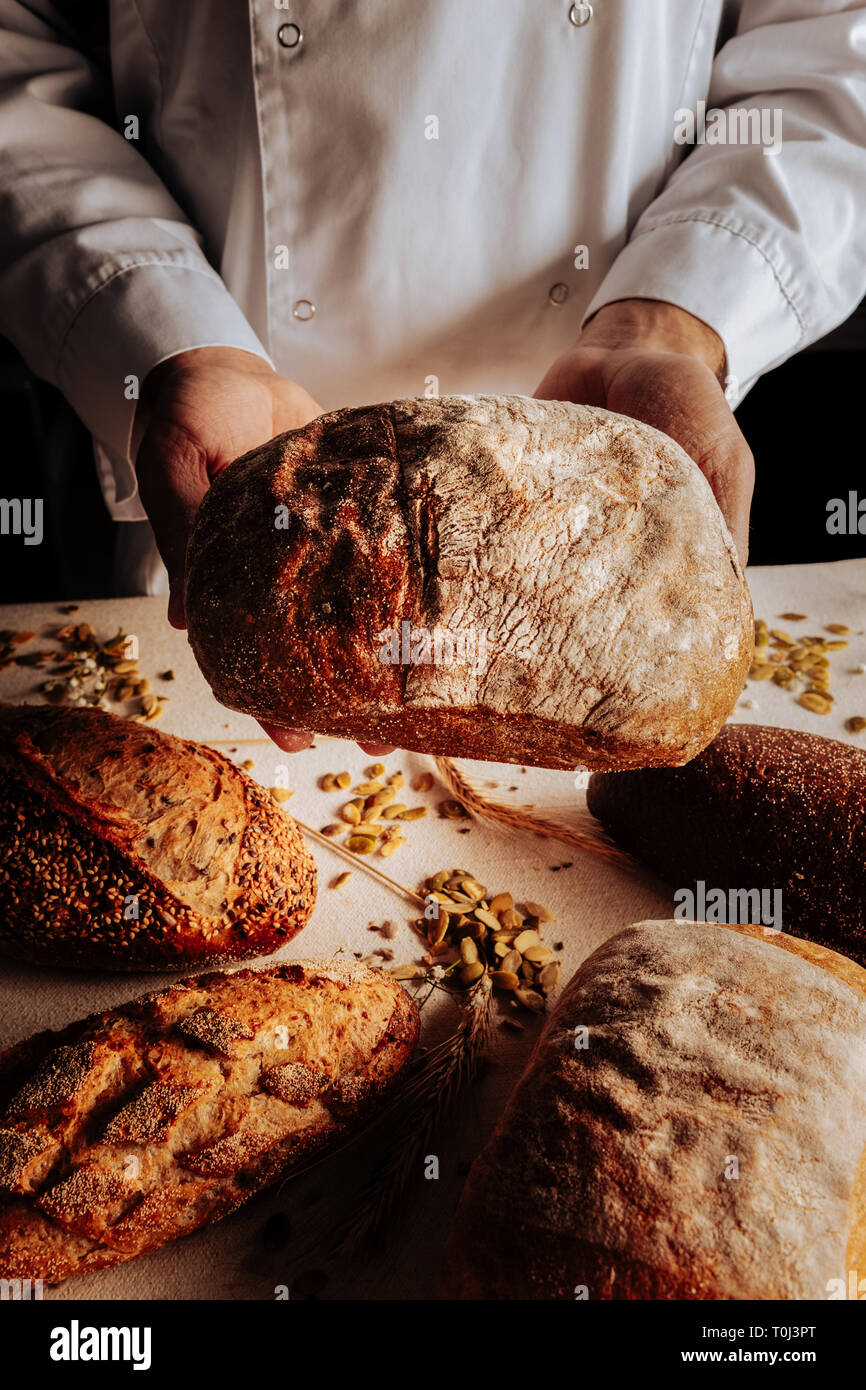 Nice wheat bread in hands of professional experienced baker Stock Photo ...