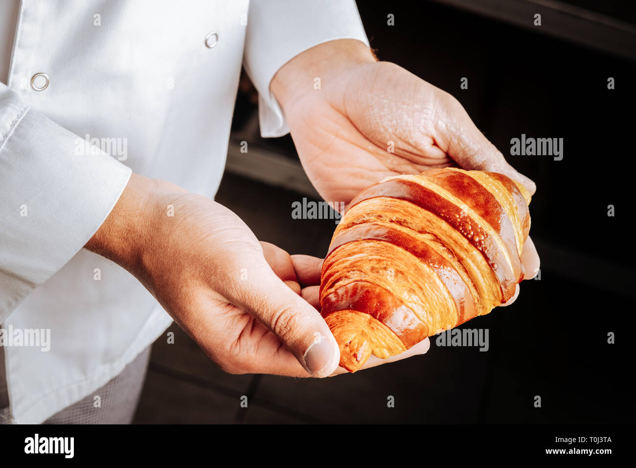 Yummy French croissant in hands of professional baker Stock Photo - Alamy
