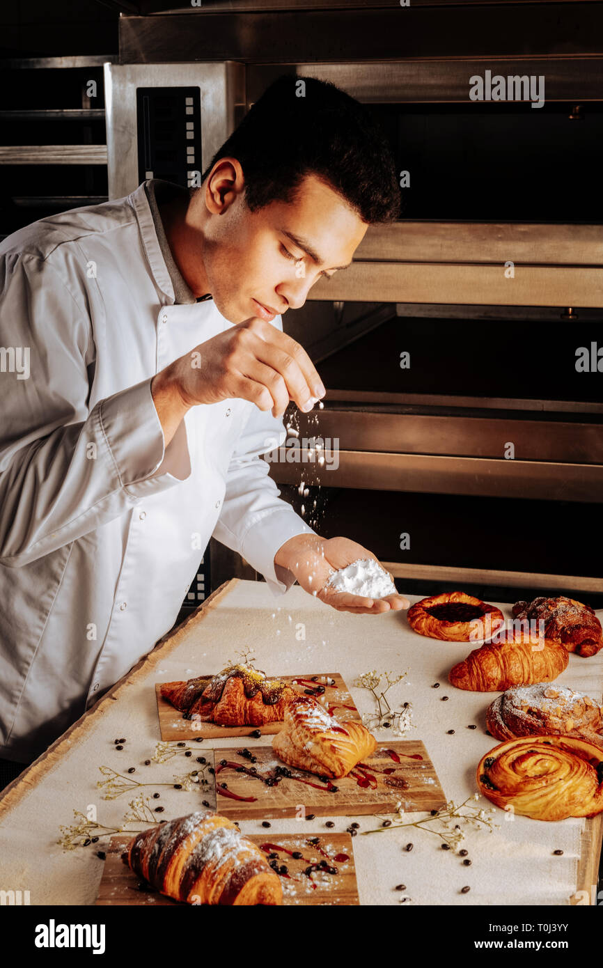 Professional baker feeling good while finishing decoration of pastry ...