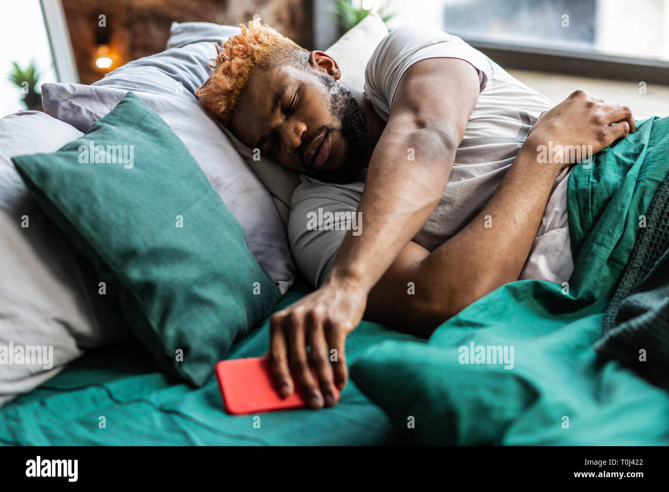 Good looking sleepy man checking the time Stock Photo - Alamy