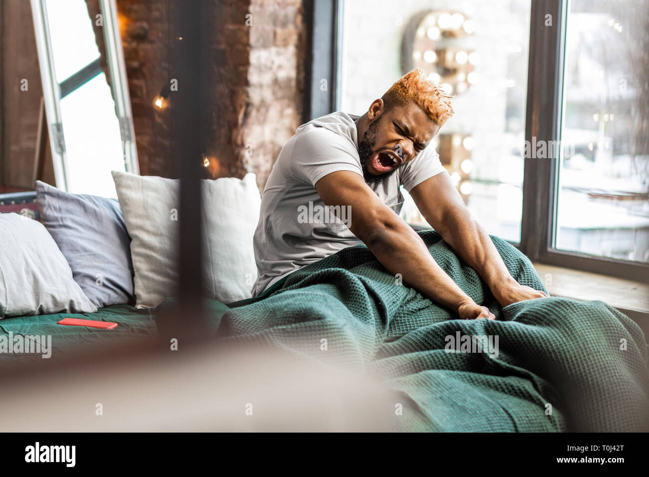 Nice pleasant young man being still sleepy Stock Photo - Alamy