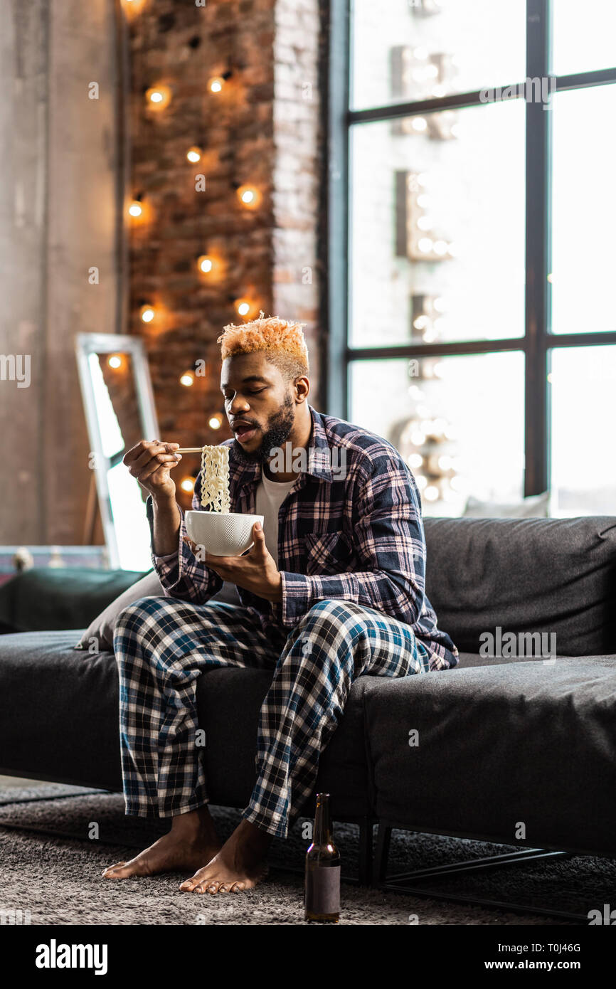 Nice pleasant young man being very hungry Stock Photo - Alamy