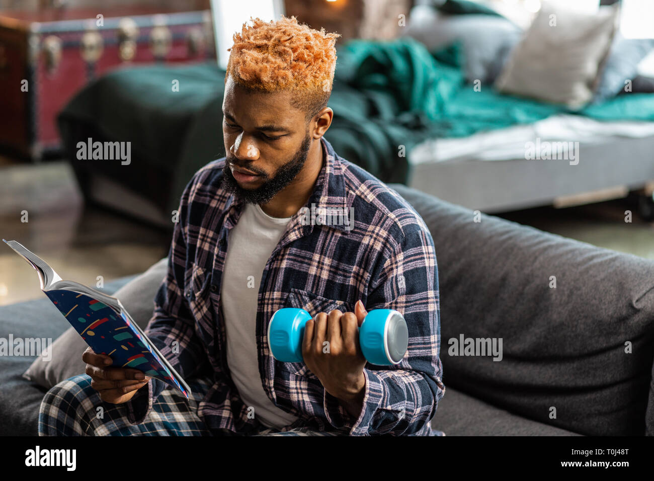 Smart nice man doing an exercise with a dumbbell Stock Photo - Alamy