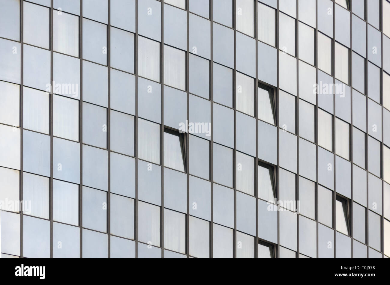 Rounded wall of glass business building with some windows open. Full ...
