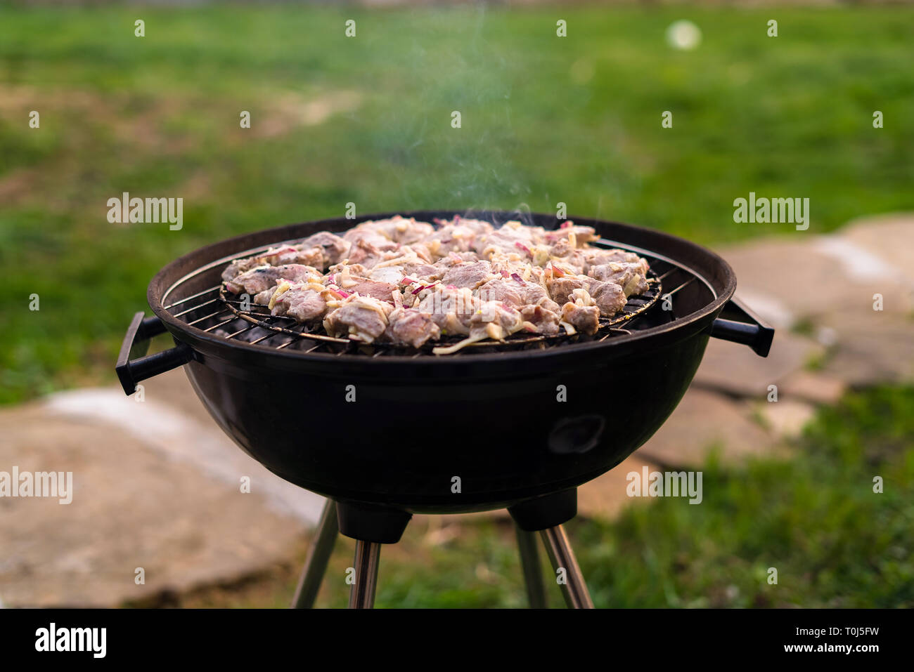 Grilling barbeque meet on the grill outdoors in the back yard. Summer ...
