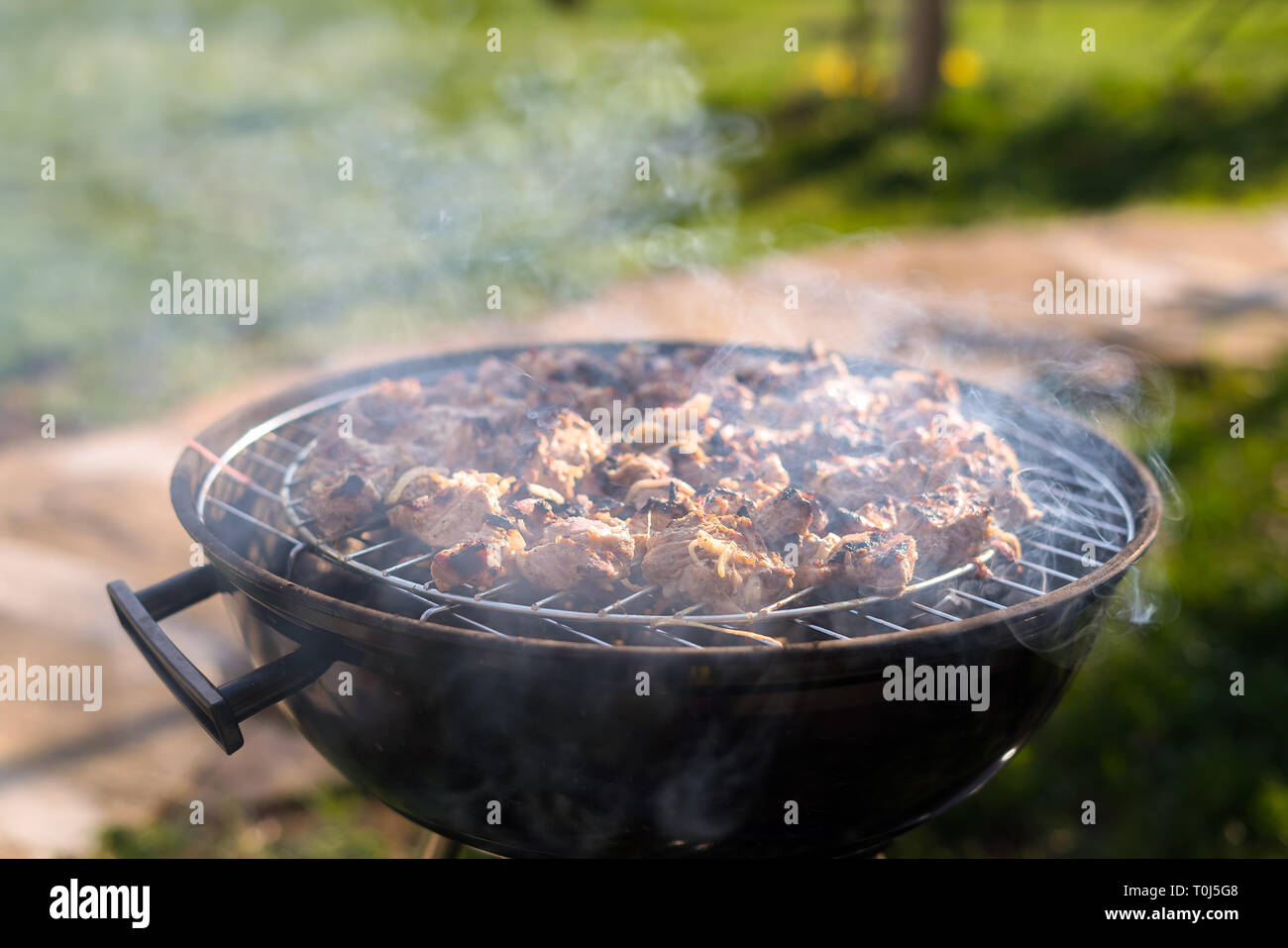 Grilling barbeque meet on the grill outdoors in the back yard. Summer ...