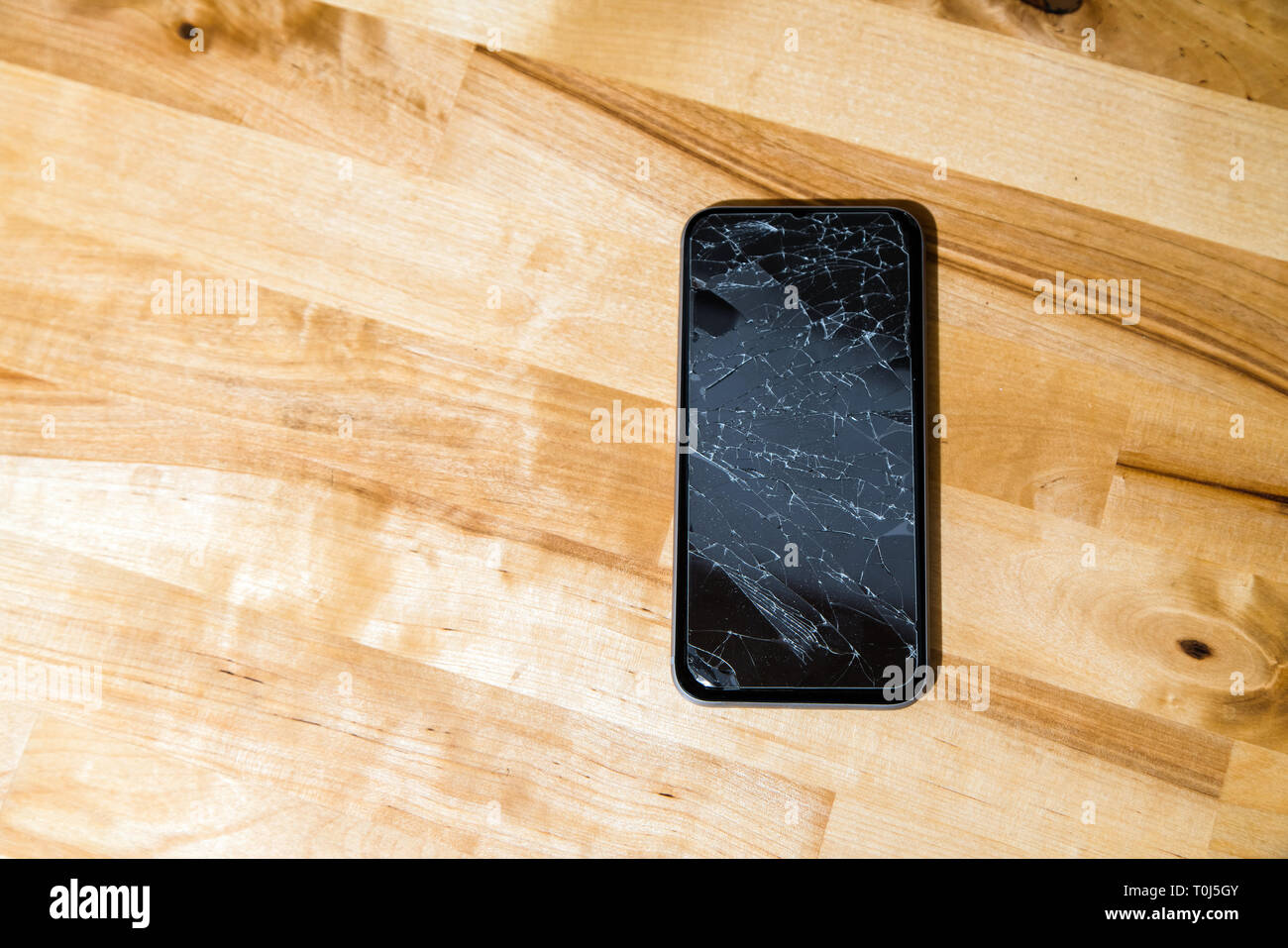 Concept of smart phone with broken screen. Top view on wooden desk ...