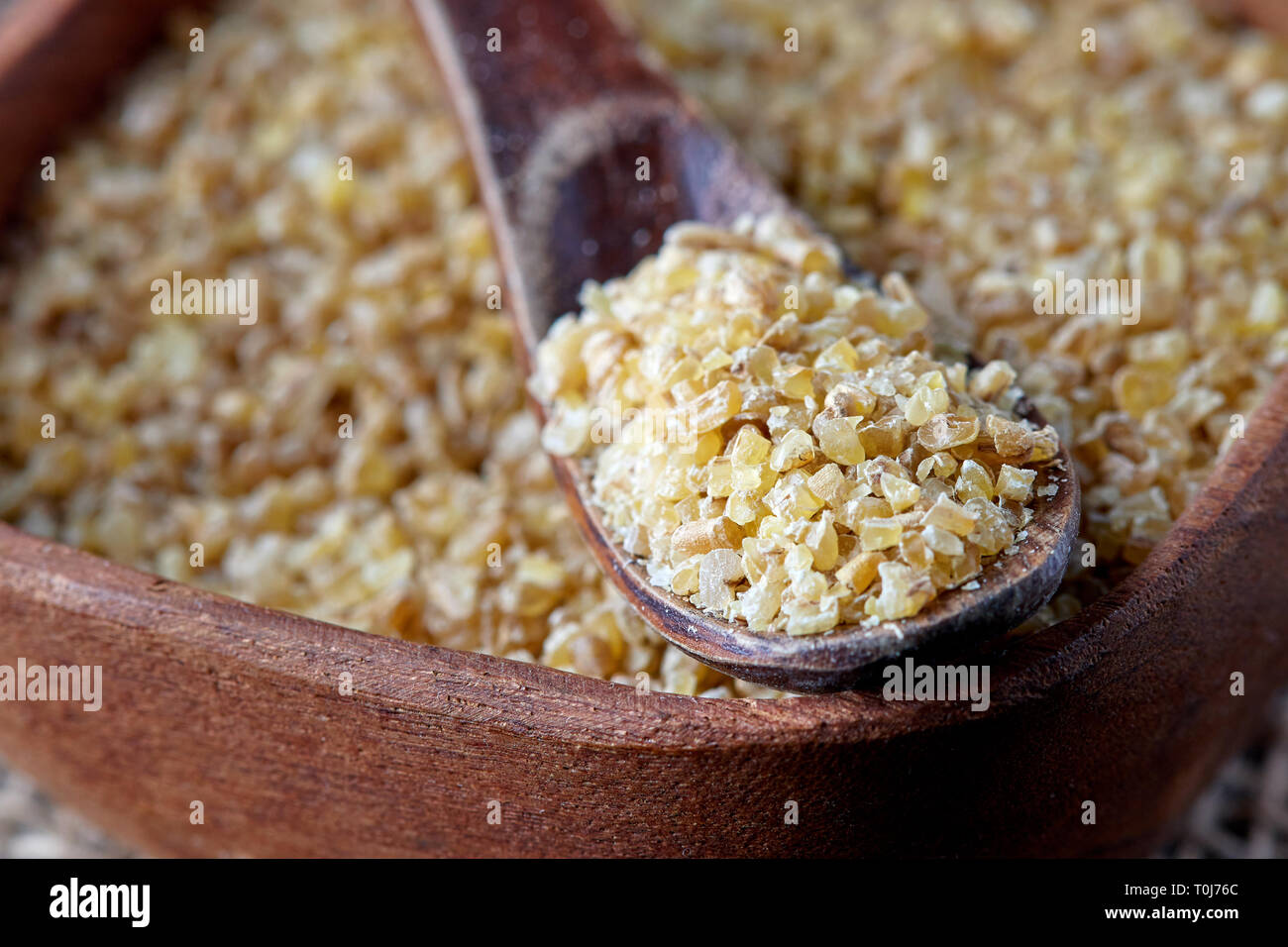 Uncooked raw bulgur wheat grains in wooden bowl Stock Photo - Alamy