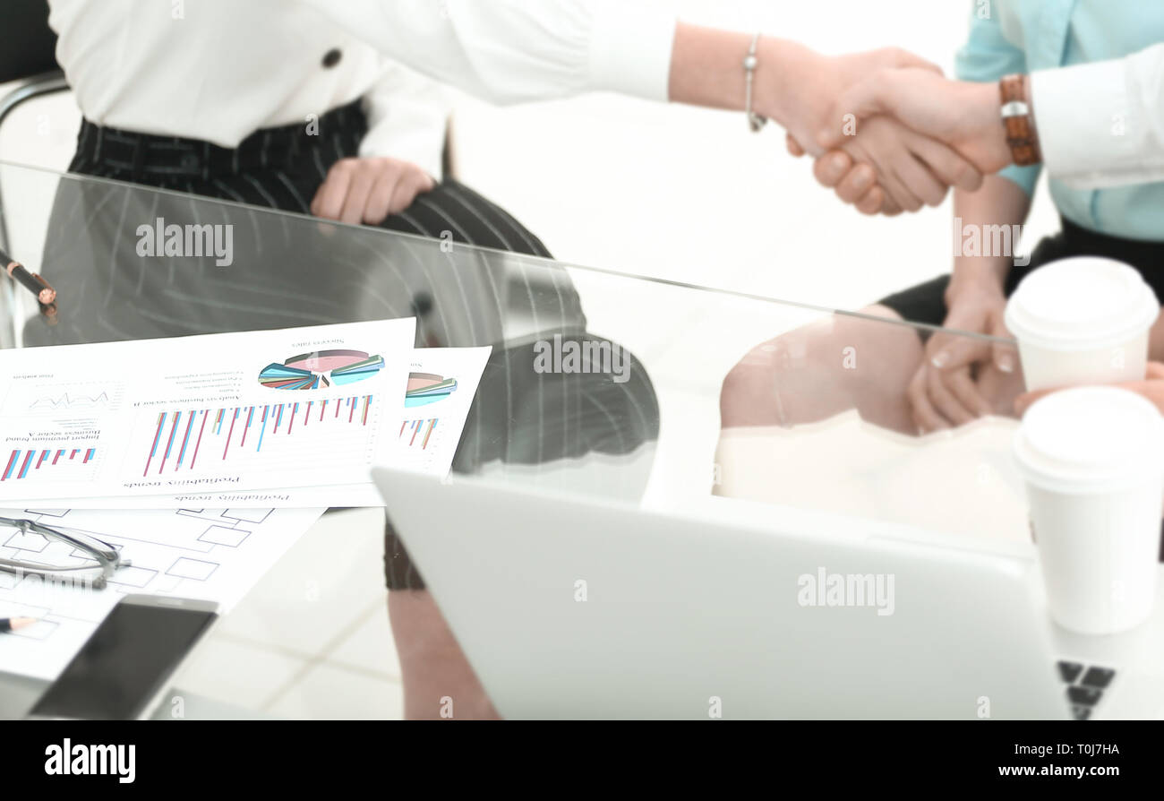 close up.handshake financial partners sitting at the Desk Stock Photo ...