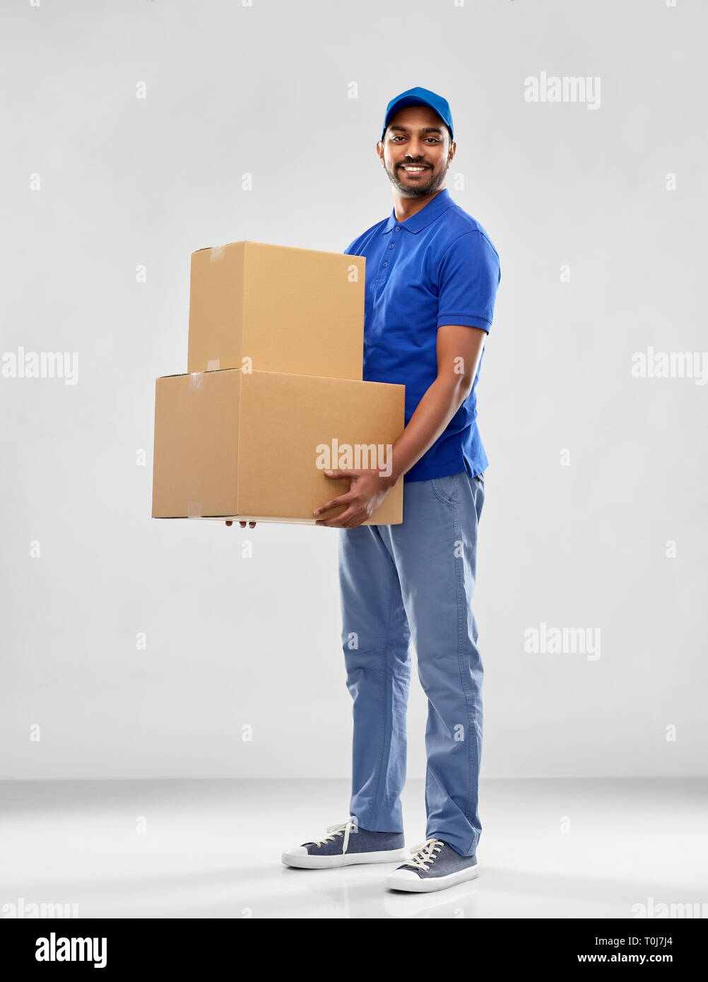 happy indian delivery man with parcel boxes Stock Photo - Alamy