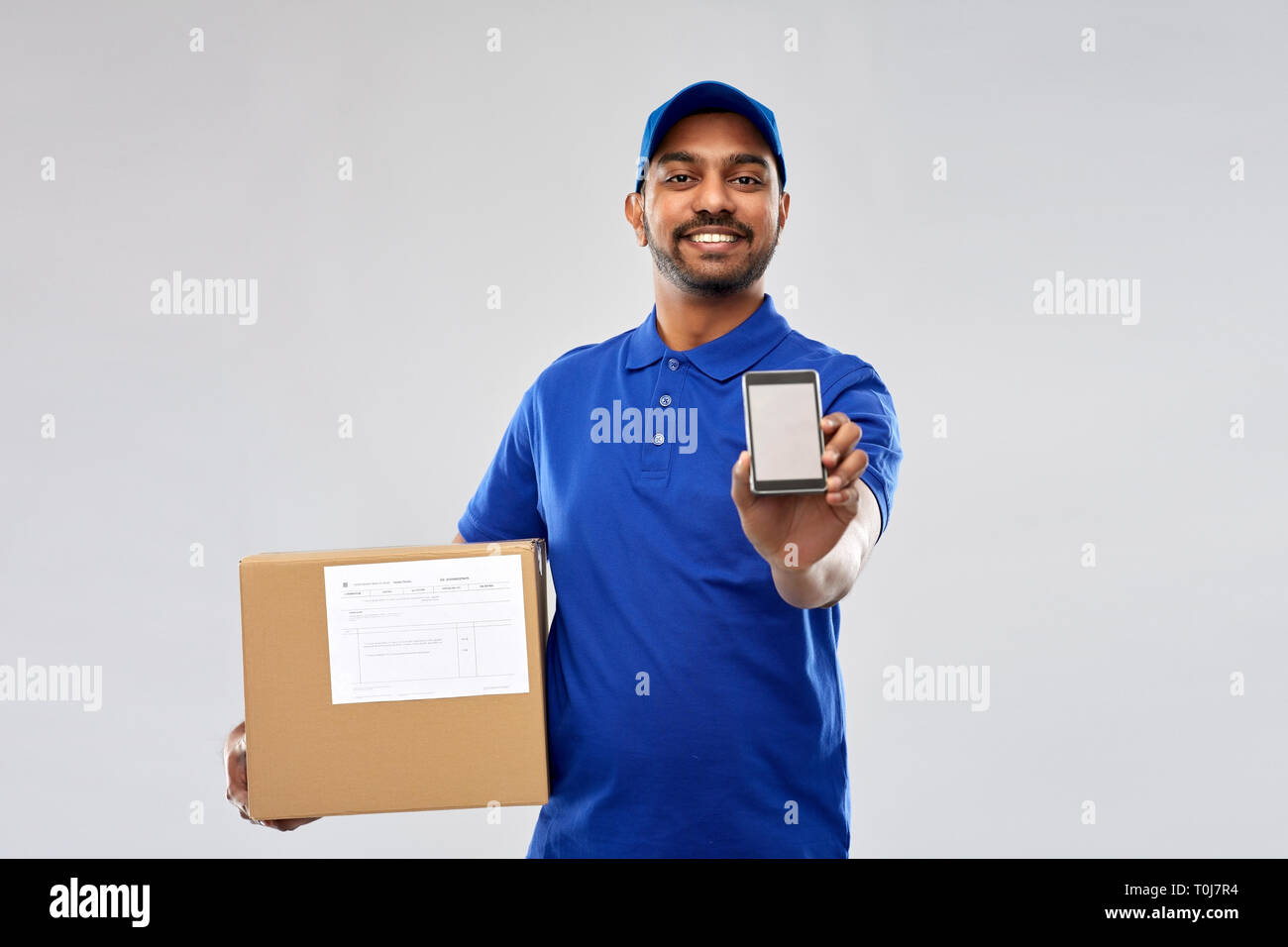 indian delivery man with smartphone and parcel box Stock Photo - Alamy